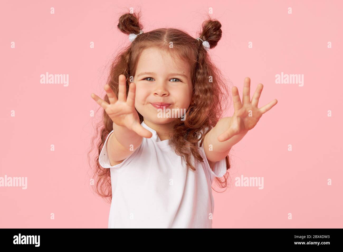 Portrait of surprised cute little toddler girl child over pink ...