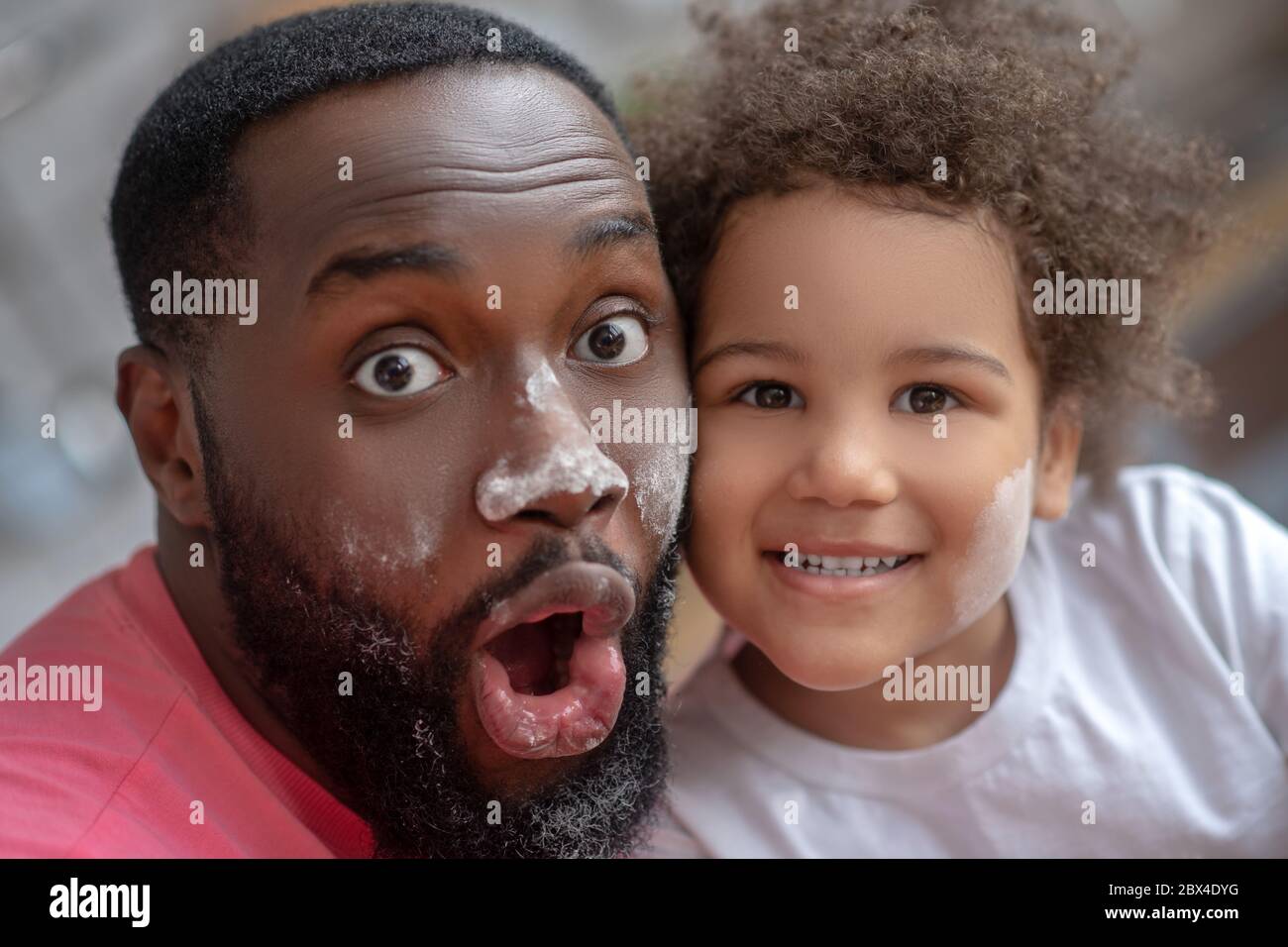 Dark-skinned father opening his mouth and looking funny with face ...
