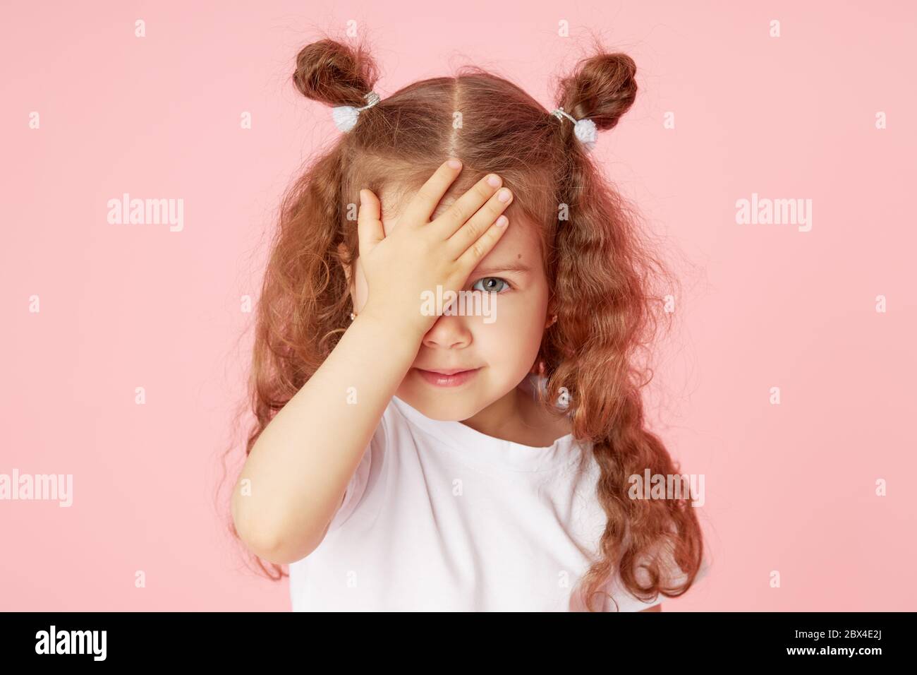 Portrait of surprised cute little toddler girl child over pink ...