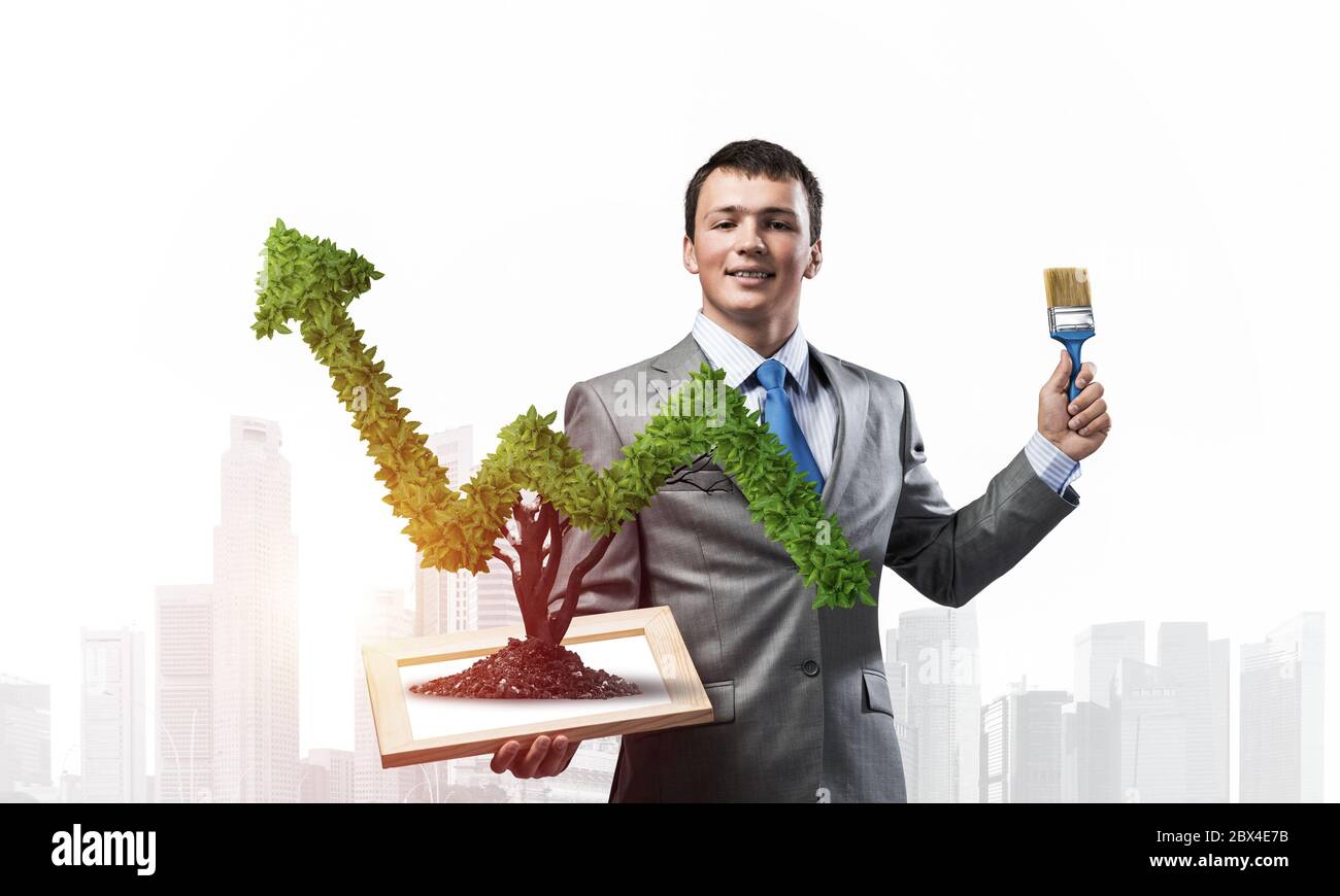 Creative businessman painter holding paintbrush Stock Photo - Alamy