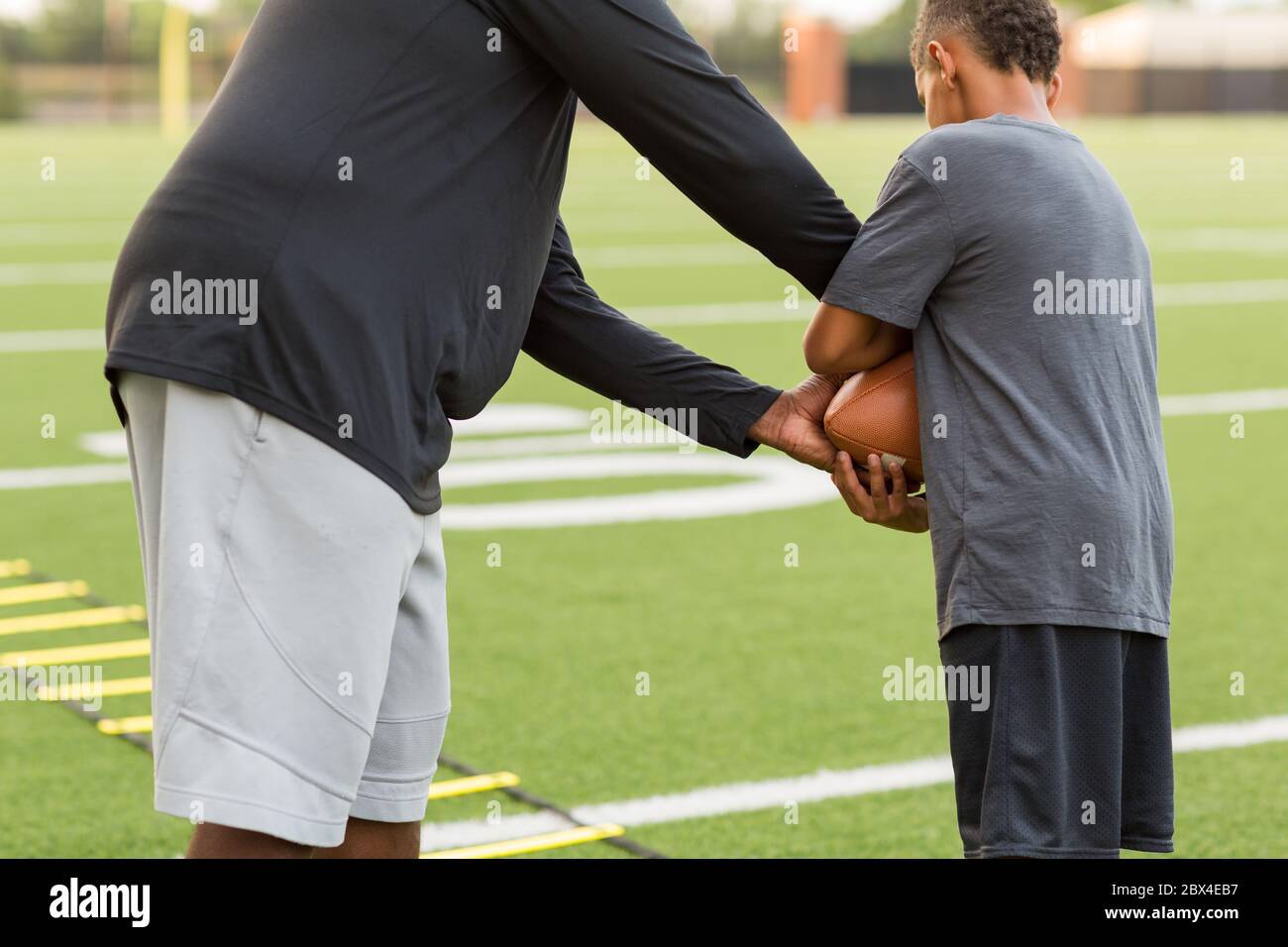 American Football coach training a young athlete Stock Photo - Alamy