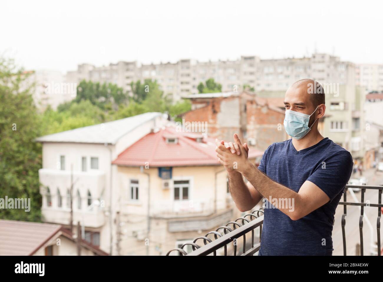 Man congratulate medical staff clapping from his apartment balcony ...