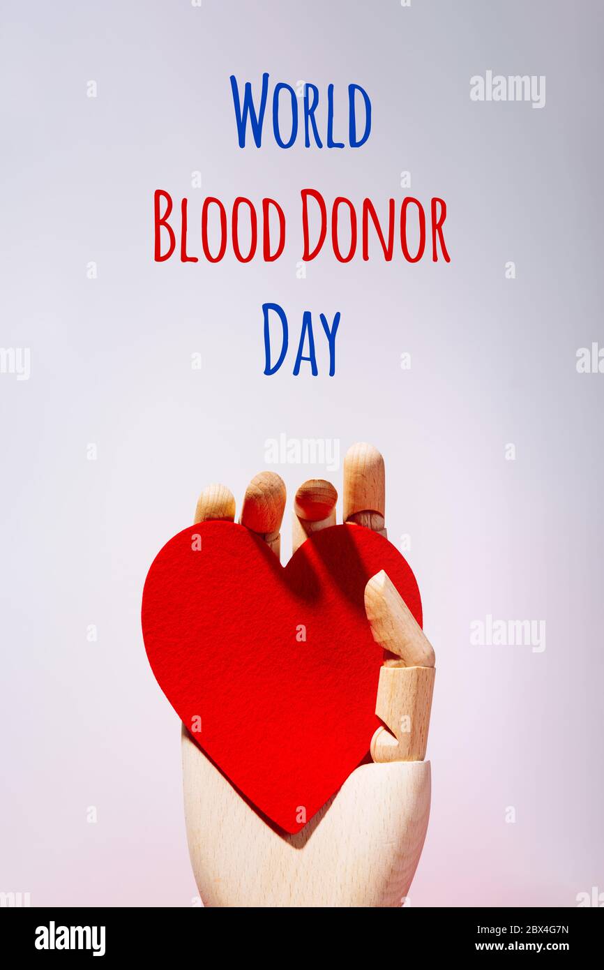 Wooden hand with big red heart in a giving gesture. World Blood Donor ...