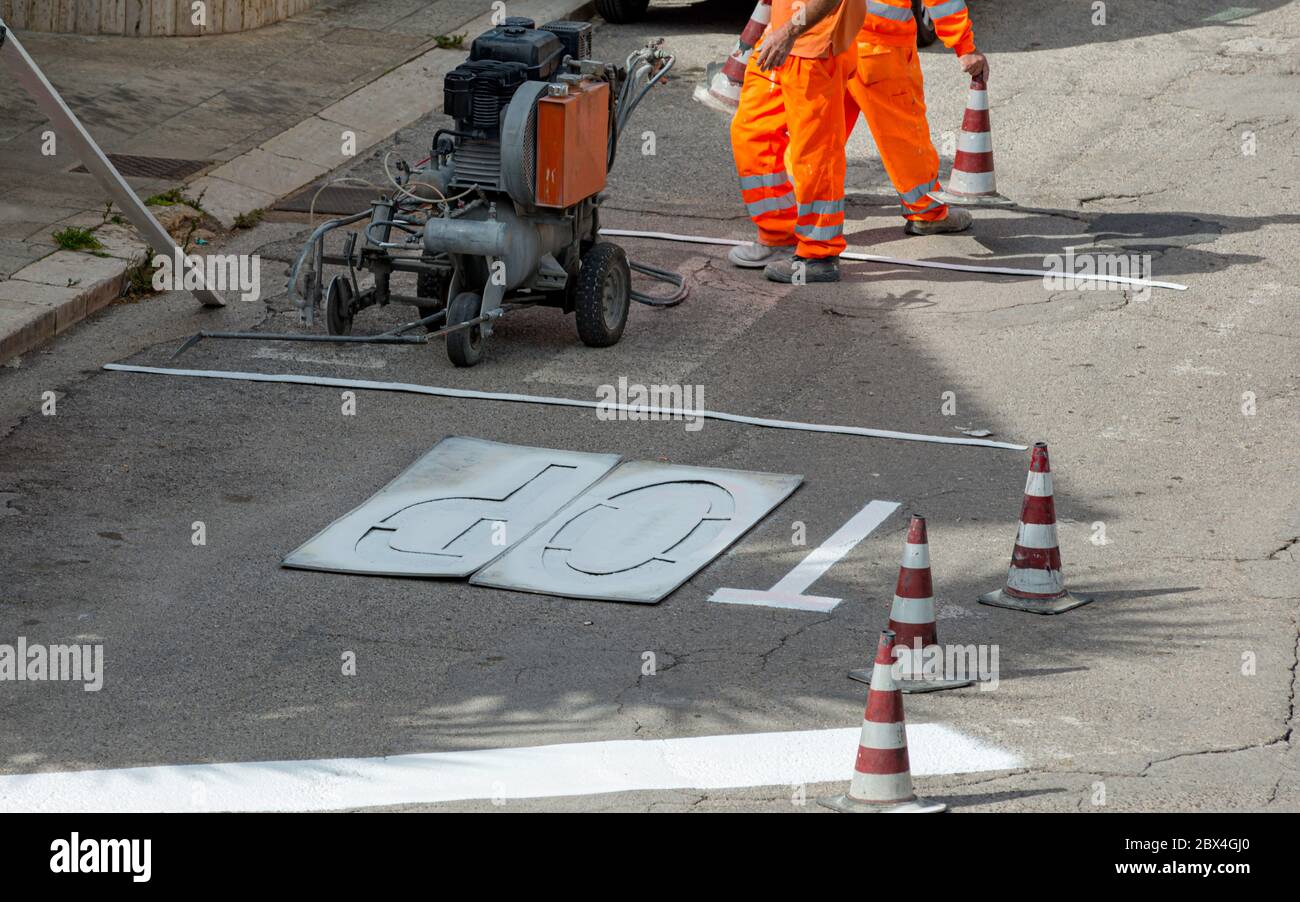 machine and workers at road construction use for road and traffic sign ...