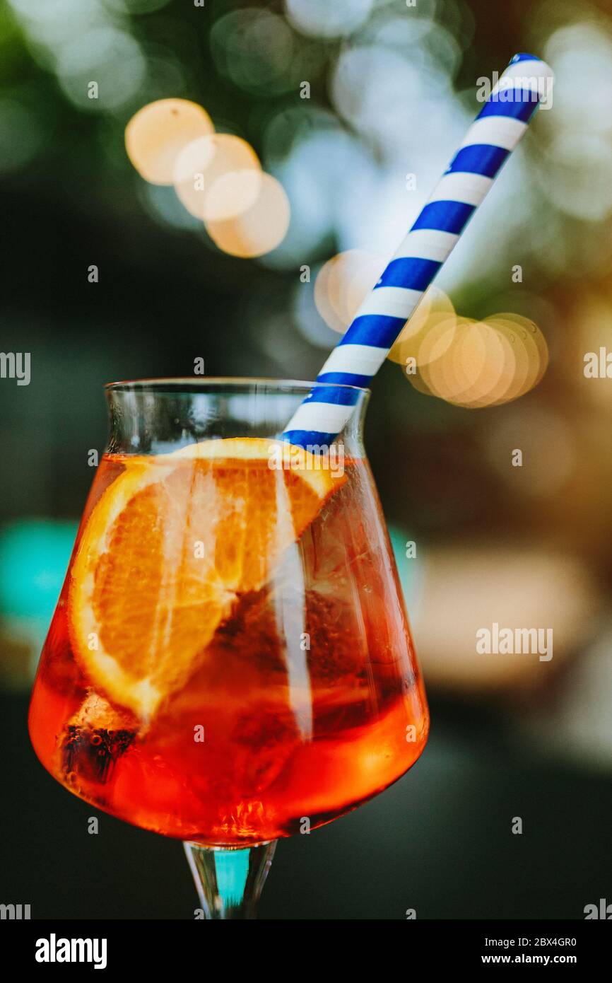 Glass of Aperol Spritz and blue straw, Italian Cocktail. Fine film ...