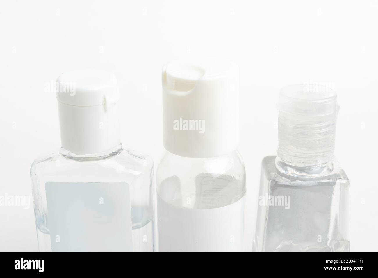 A product shot of three generic pocket-size transparent hand sanitizer ...