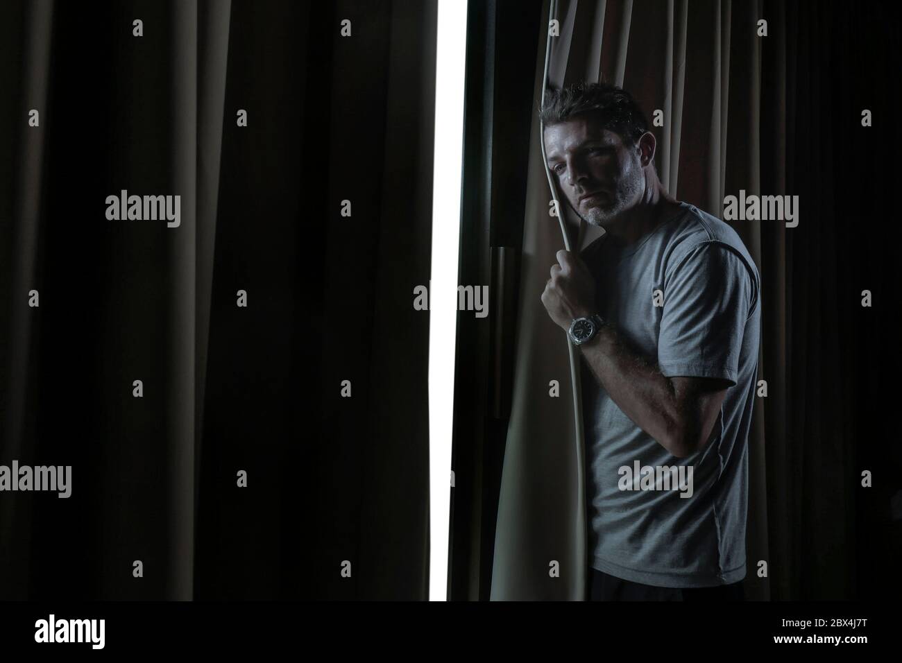 dramatic light indoors portrait of young sad and depressed attractive ...