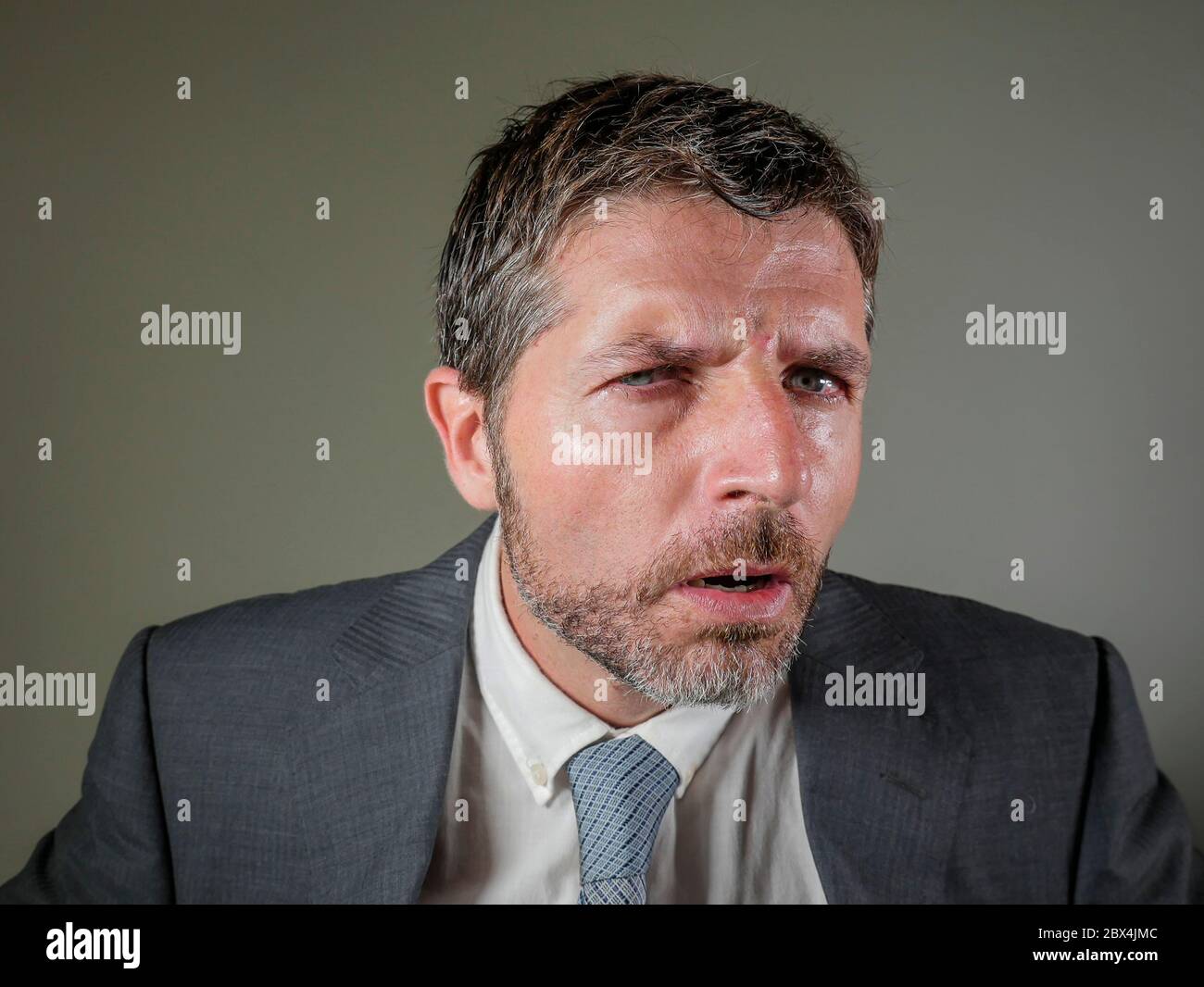 close up face portrait of young angry and unhappy businessman in suit ...