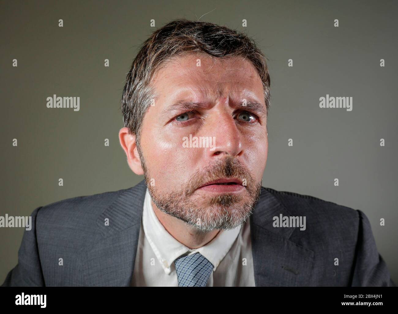 close up face portrait of young angry and unhappy businessman in suit ...