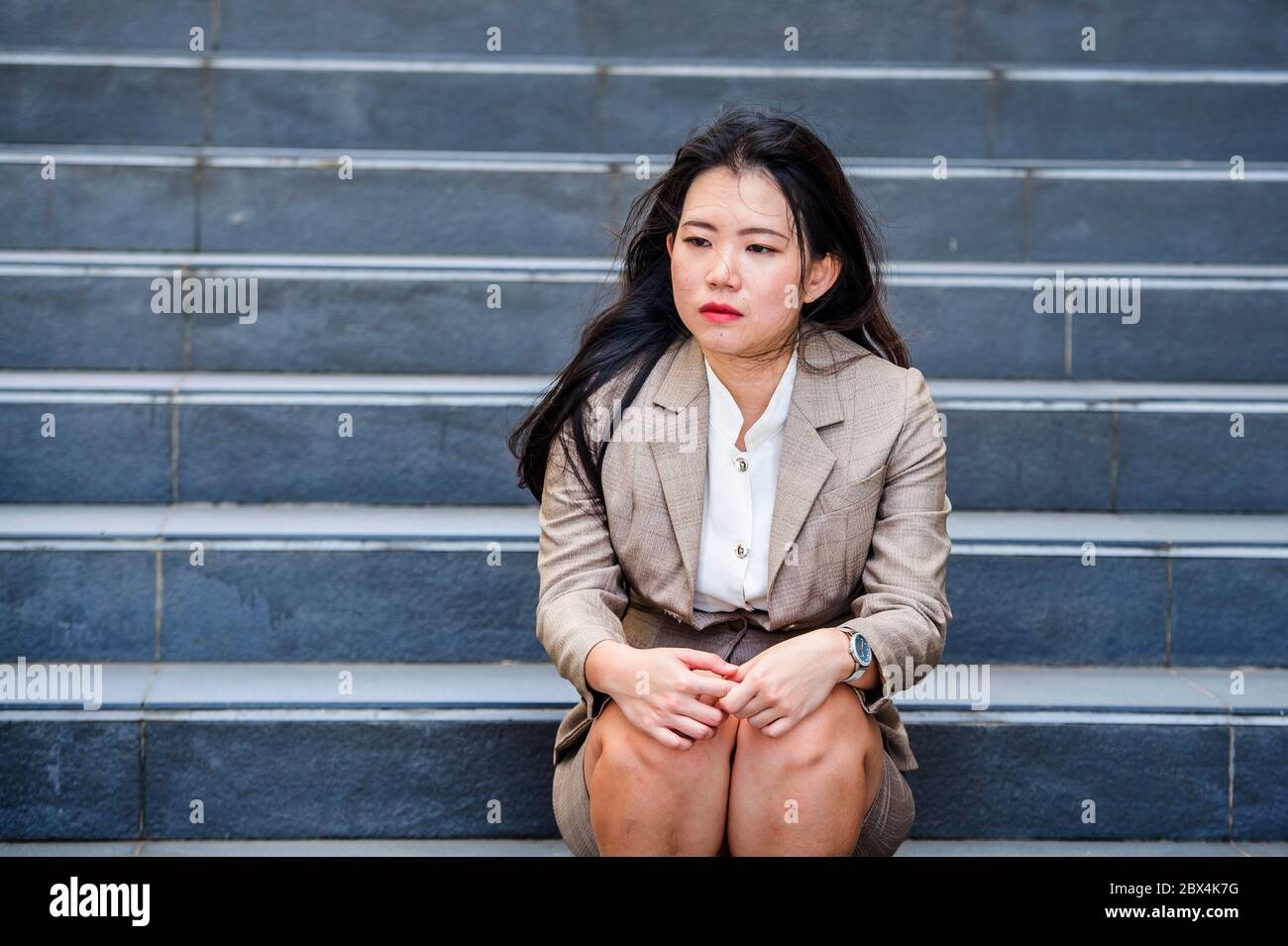 young depressed and desperate Asian Chinese businesswoman crying alone ...