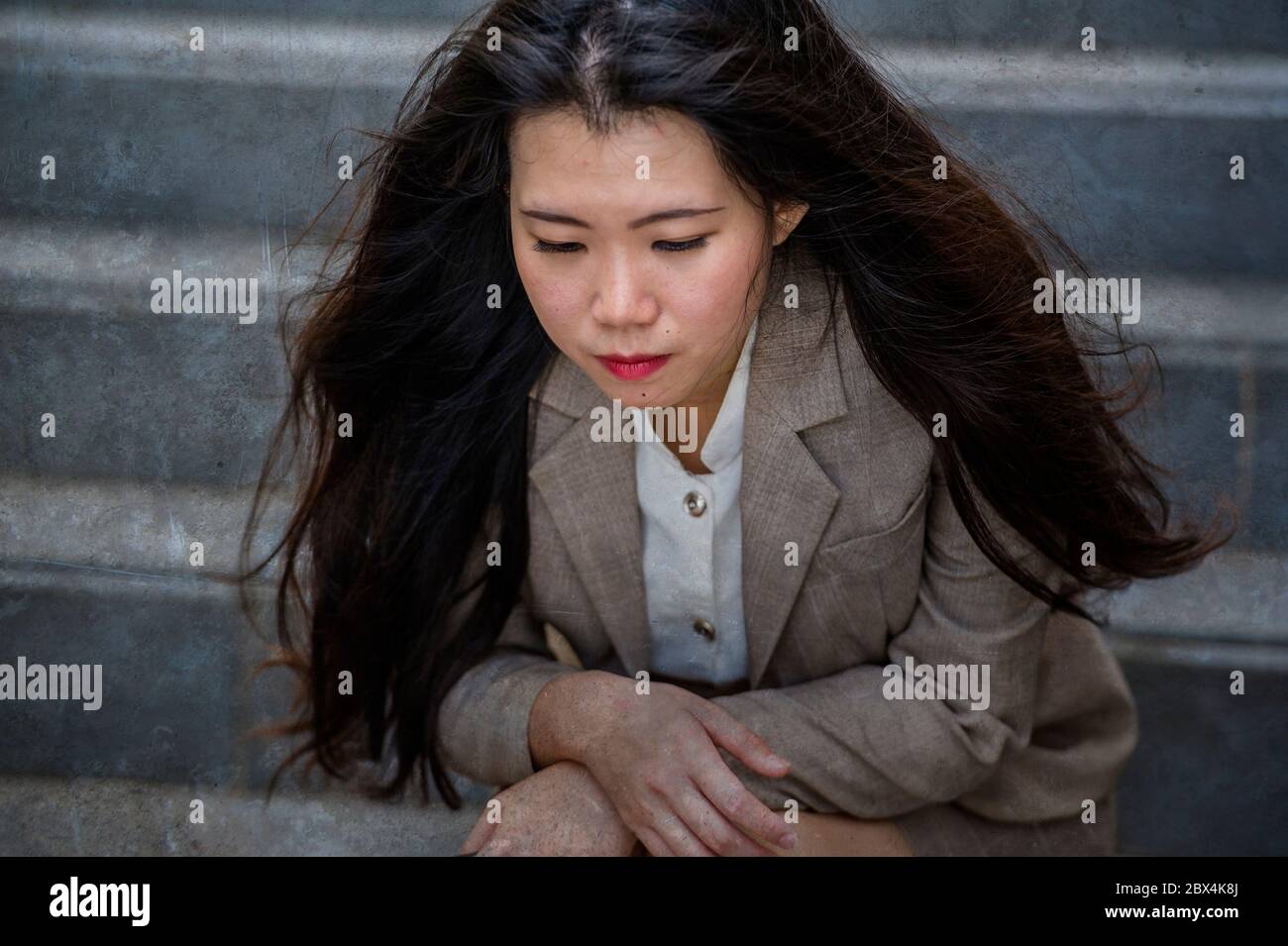young depressed and desperate Asian Chinese businesswoman crying alone ...