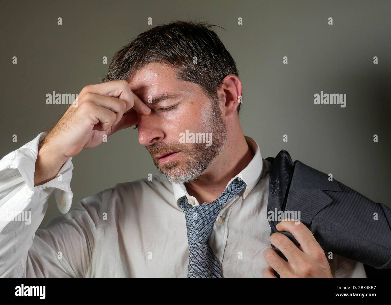young attractive sad and worried businessman in lose tie and messy look ...