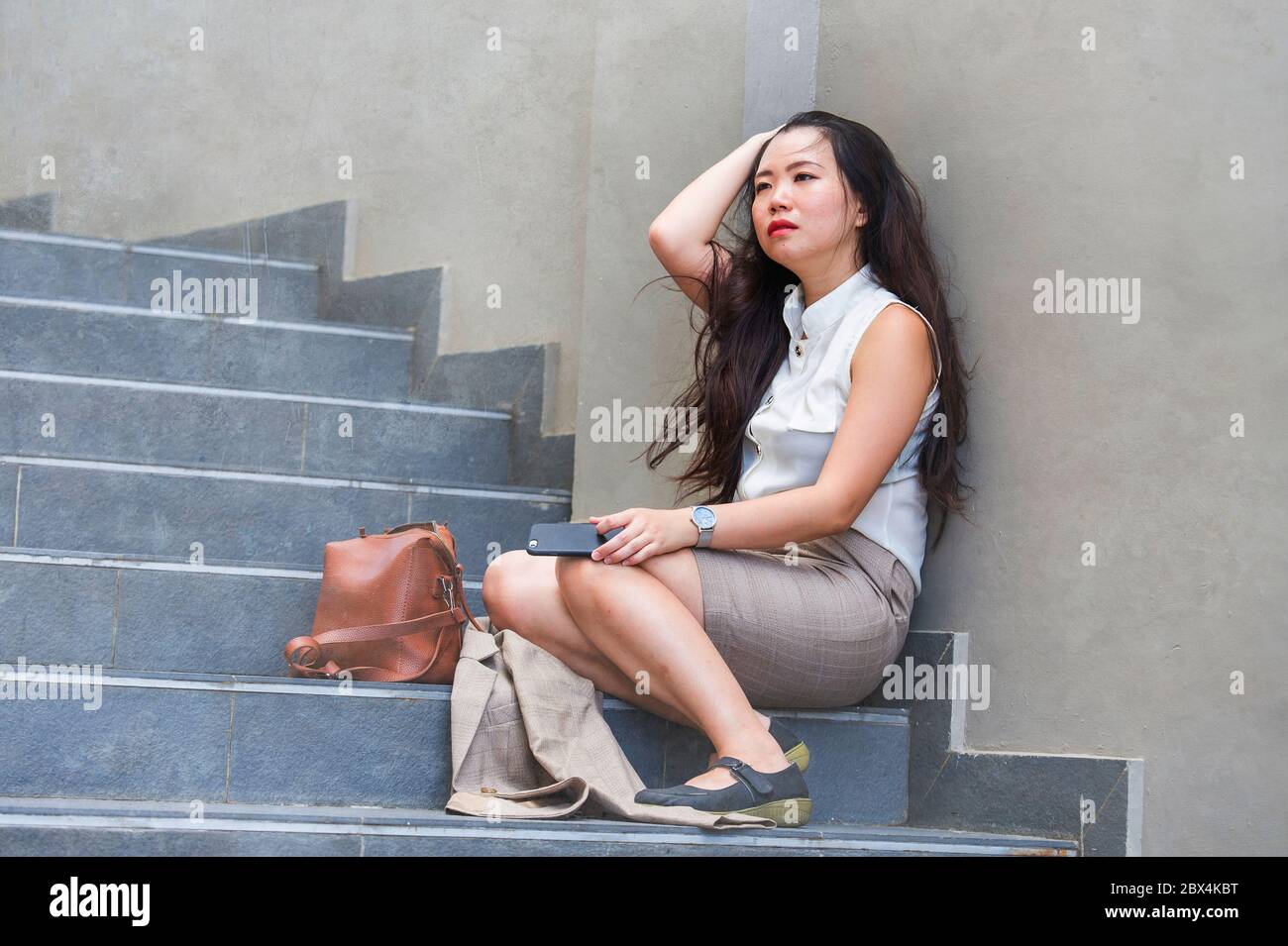 young depressed and desperate Asian Chinese businesswoman crying alone ...