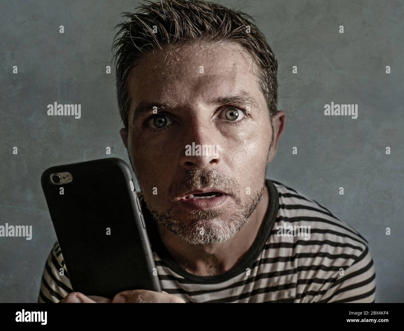 young weird and crazy mobile phone addict man using cell compulsively ...