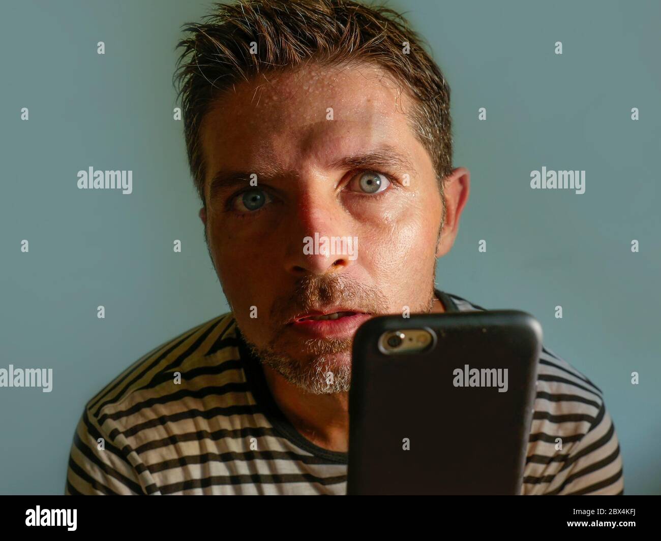 young weird and crazy mobile phone addict man using cell compulsively ...