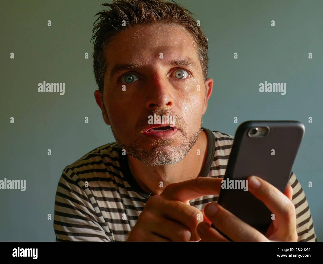 young weird and crazy mobile phone addict man using cell compulsively ...