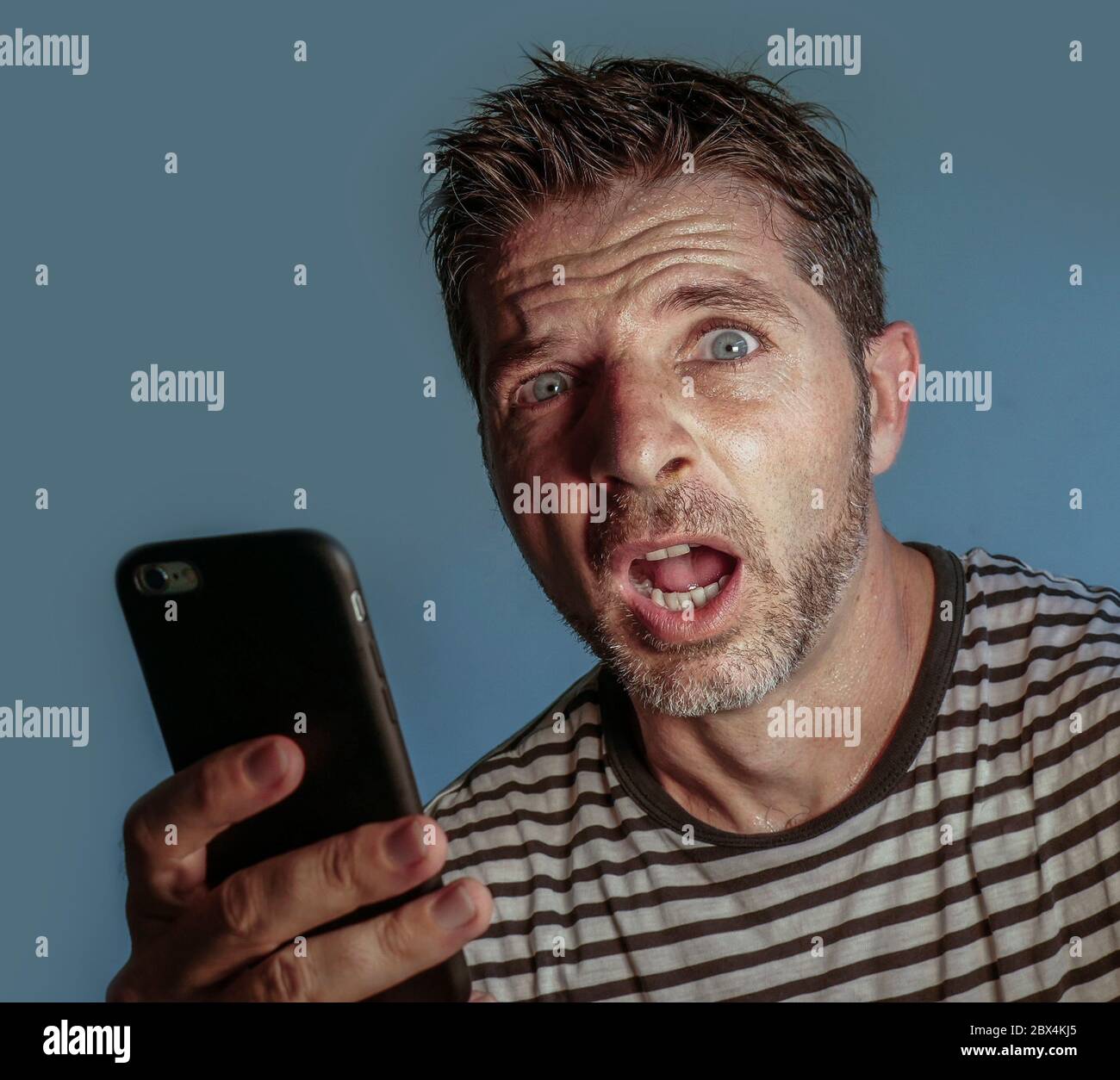 young weird and crazy mobile phone addict man using cell compulsively ...