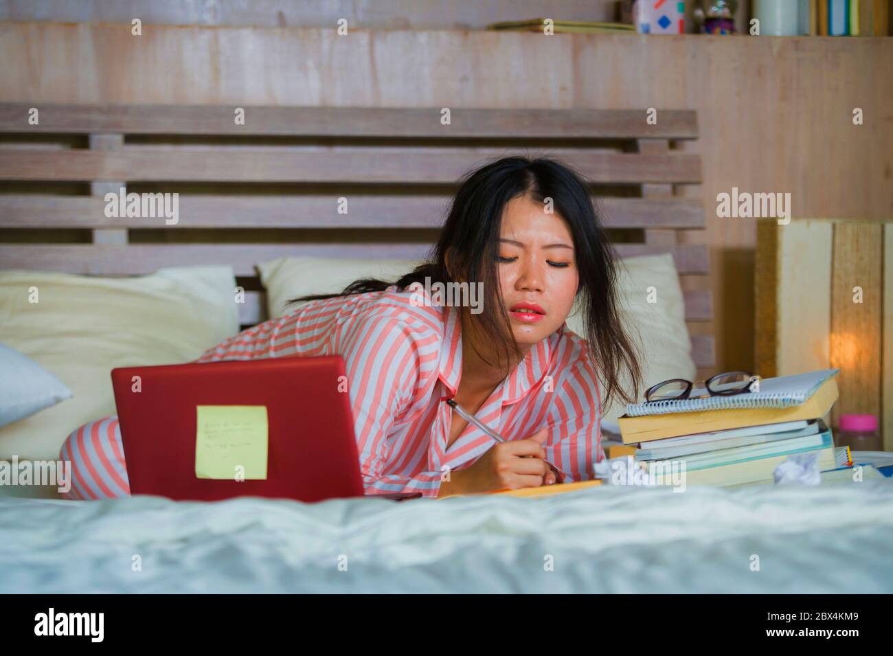 young frustrated and tired Asian Chinese university student girl ...