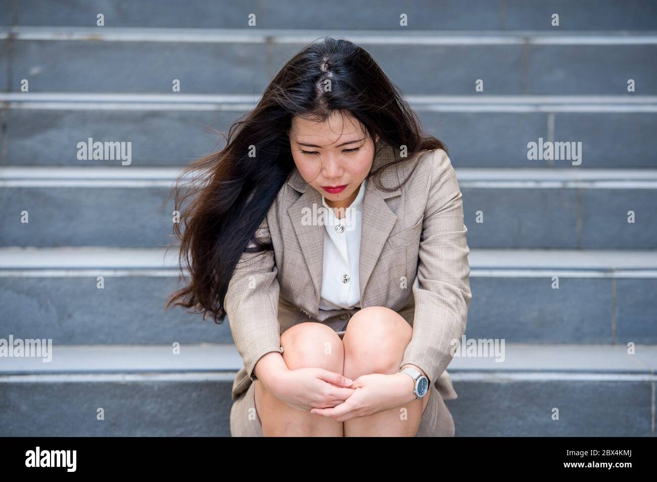 young depressed and desperate Asian Chinese businesswoman crying alone ...