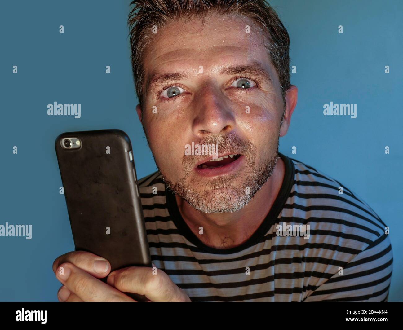 young weird and crazy mobile phone addict man using cell compulsively ...