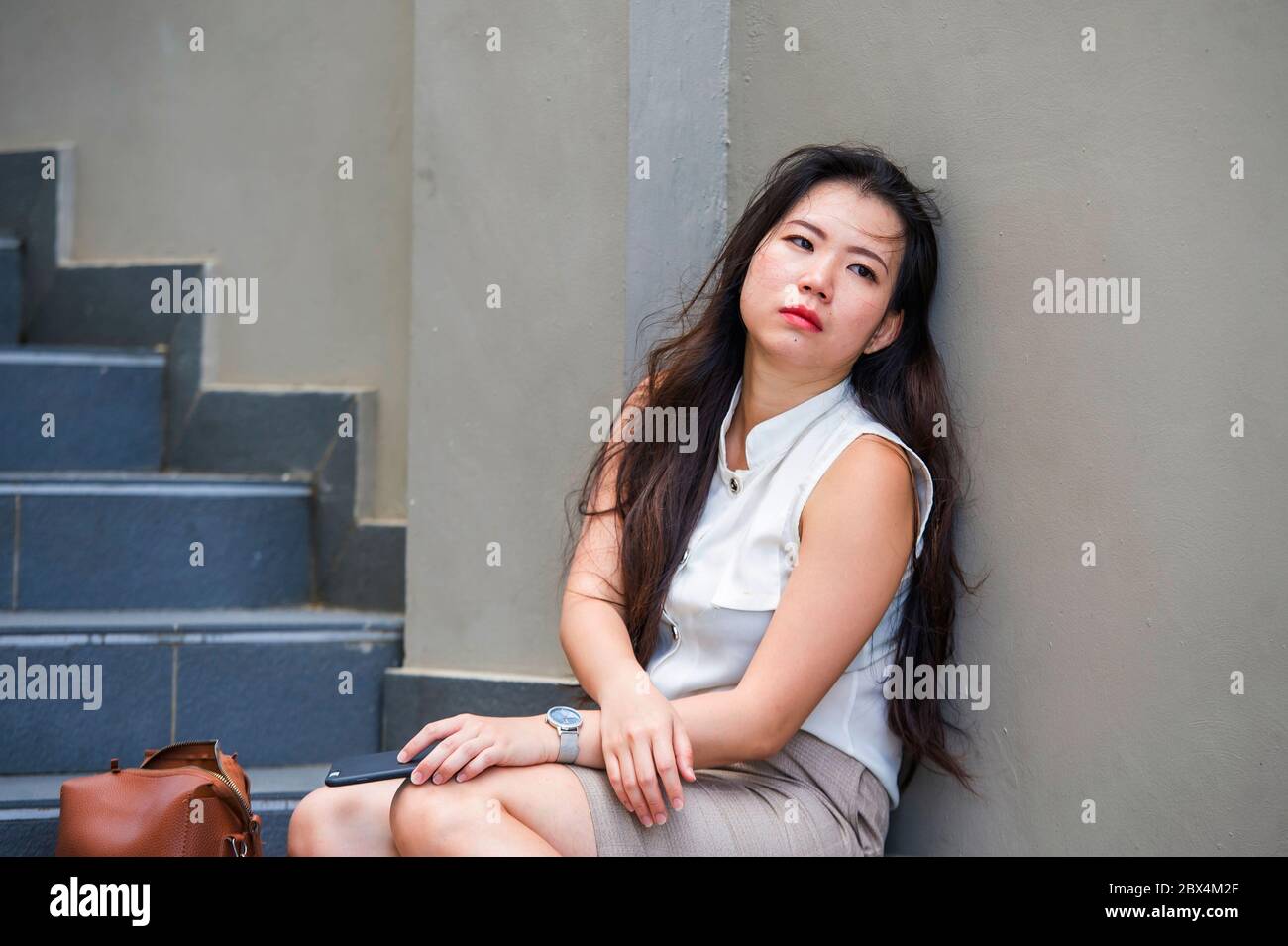 young depressed and desperate Asian Chinese business woman crying alone ...