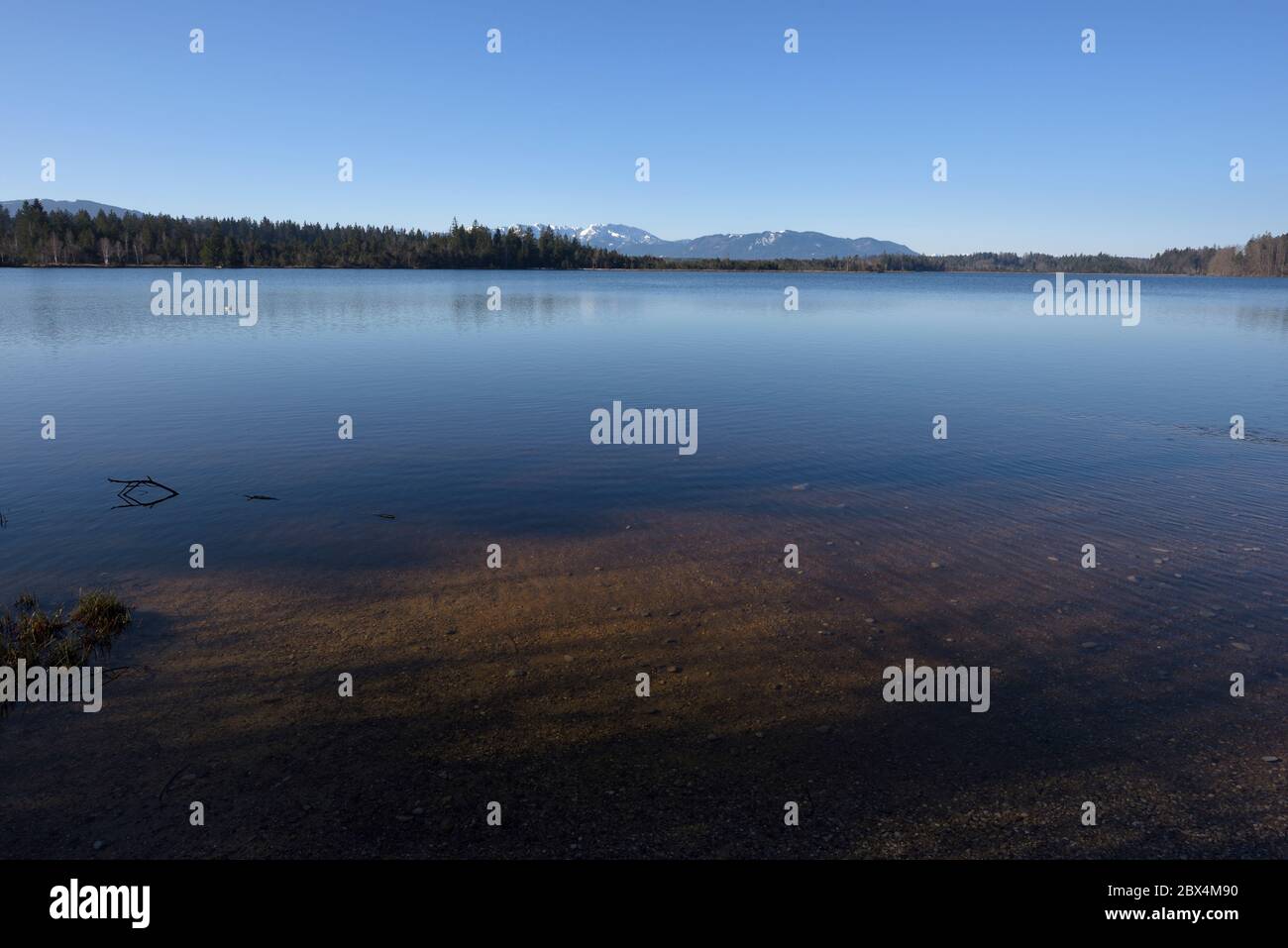 lake Kirchsee and view of snowy mountains, Bavaria, Germany Stock Photo ...