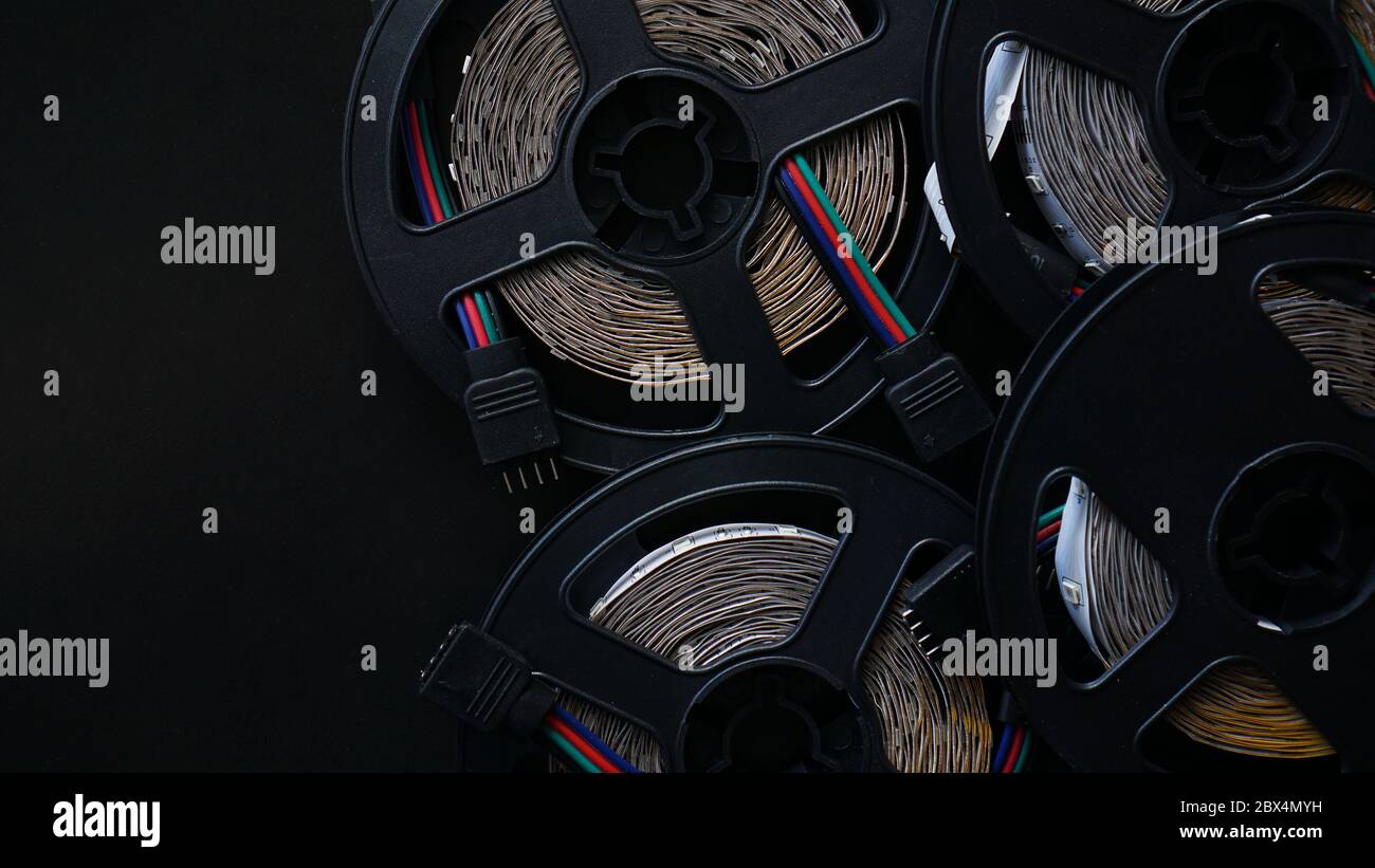 Coils of rgb led strip on a black table. Led strip for creative ...