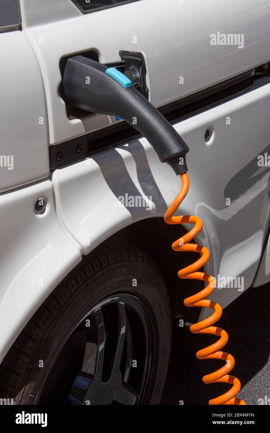 An eco-friendly car powered by electricity at a charging point on a ...
