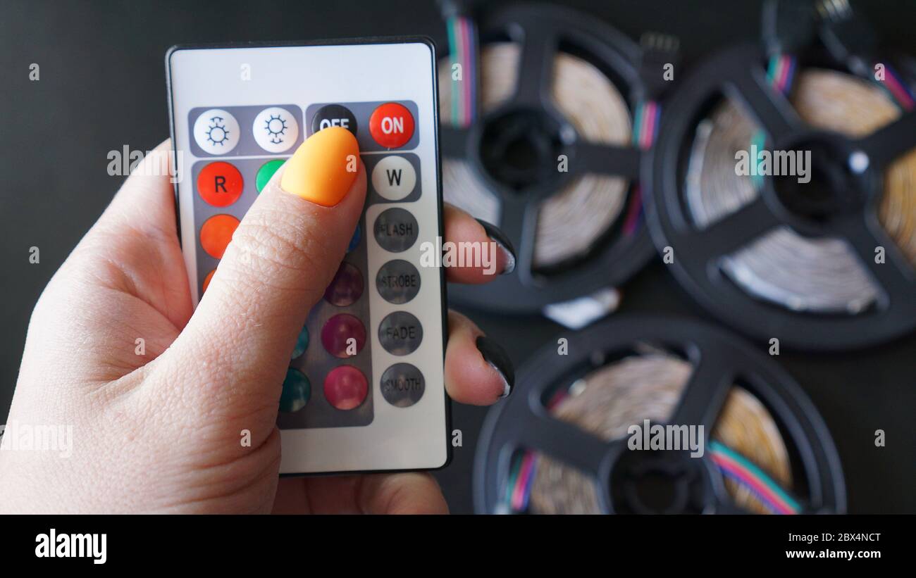 Remote control for change colors in hand on blurred background with led ...
