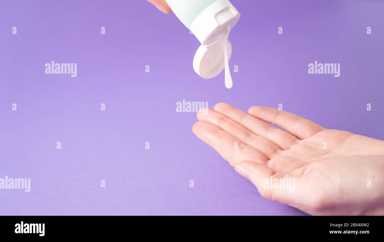 Hand cream. Pouring lotion from tube on hand. Body cream drop on hand ...