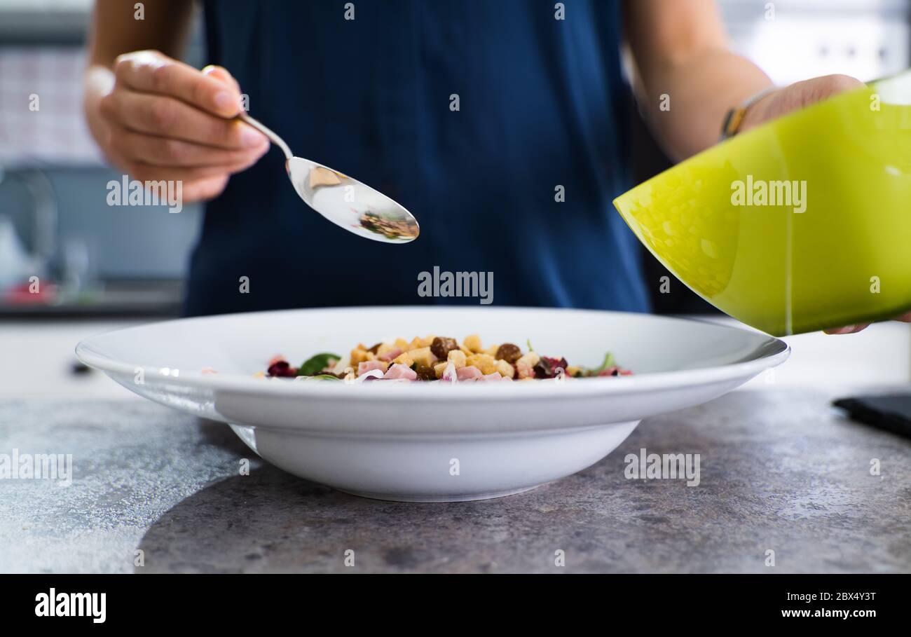 Woman Cooking Salad In Kitchen Adding Dressing Stock Photo - Alamy