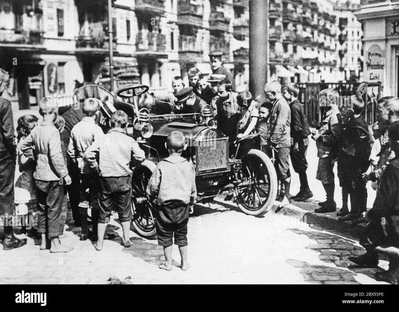 Children admire a car in Berlin. They are mostly barefoot Stock Photo ...