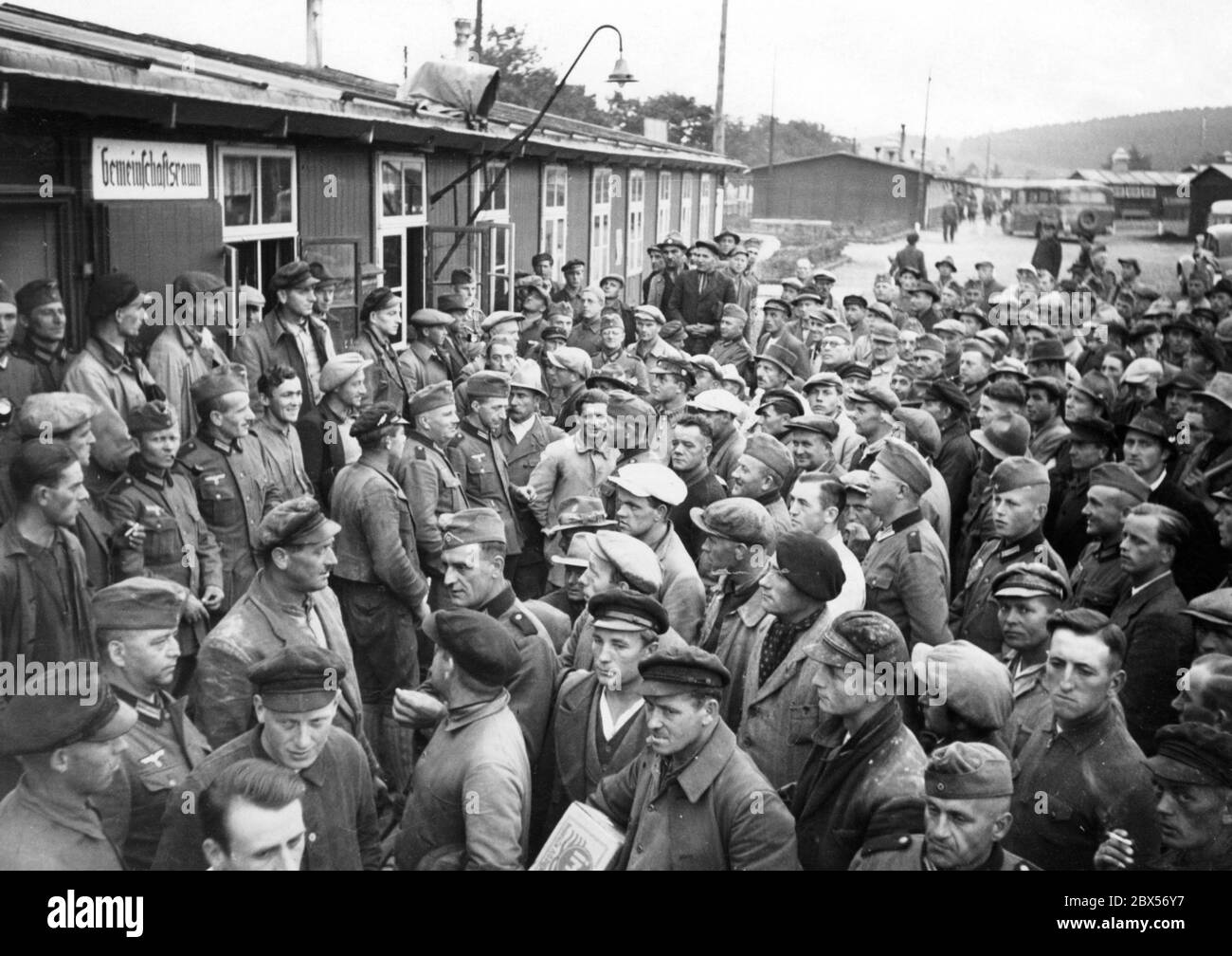 Soldiers and workers listen to a speech by Adolf Hitler in a camp on ...
