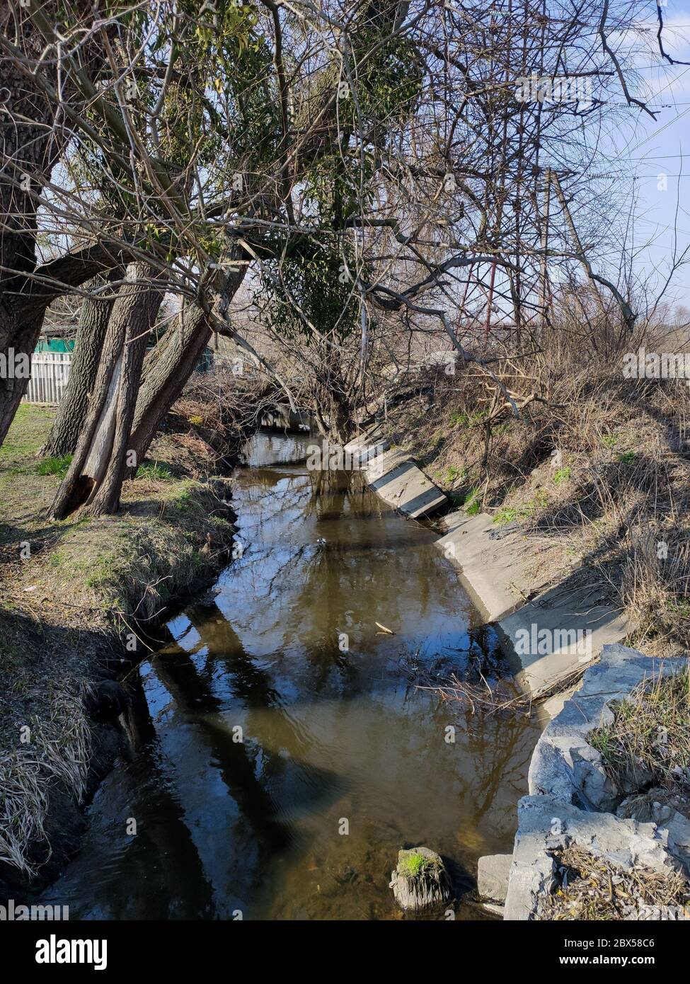 a small narrow river in the village Stock Photo - Alamy