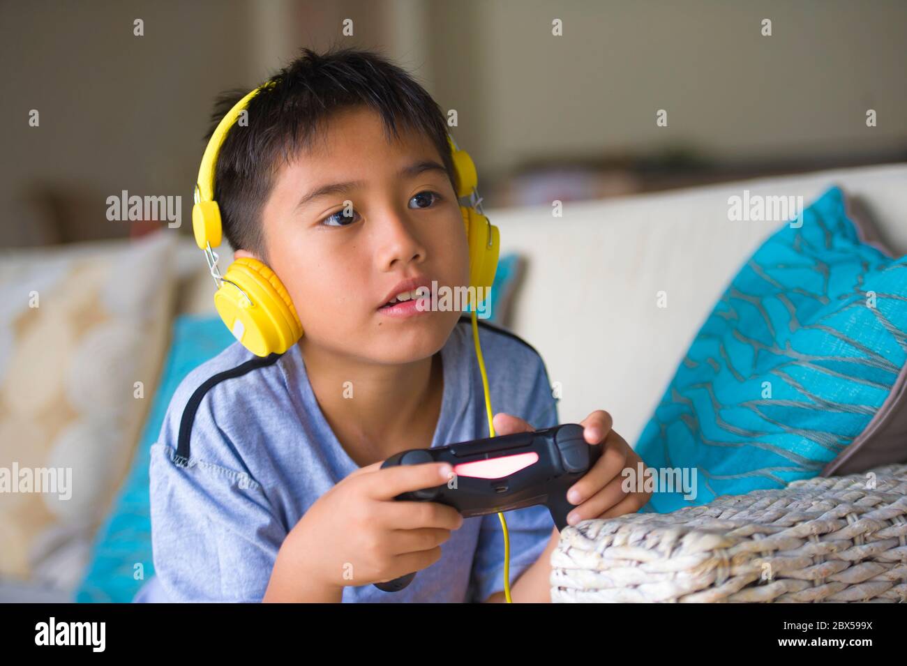 portrait of south Asian young child excited and happy playing video ...