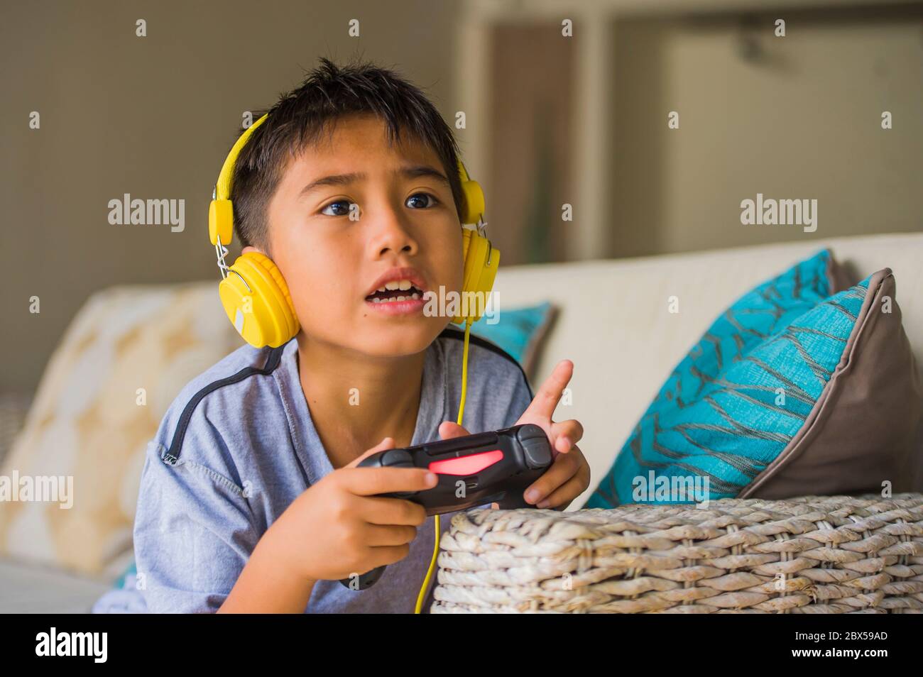 portrait of south Asian young child excited and happy playing video ...