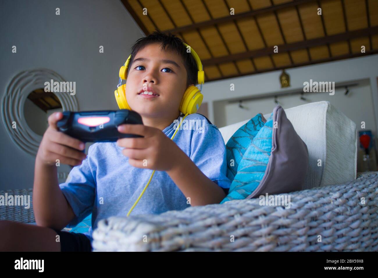lifestyle portrait of Latin little kid excited and happy playing video ...