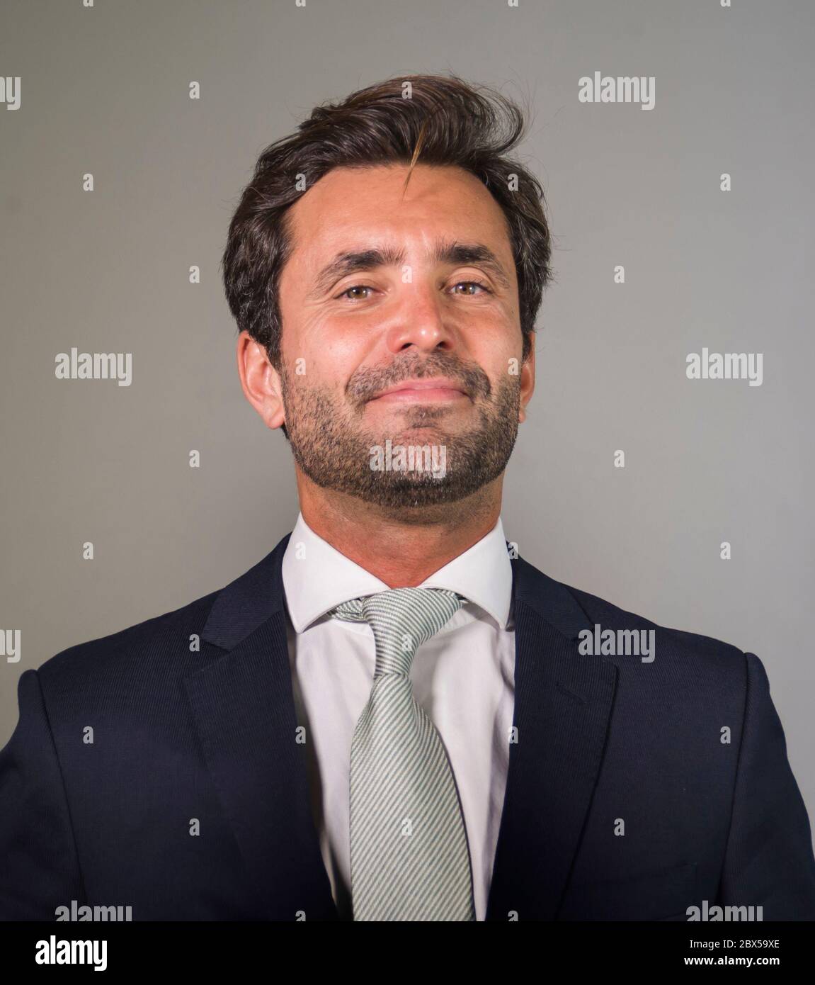 young elegant and handsome happy man in suit posing for company ...