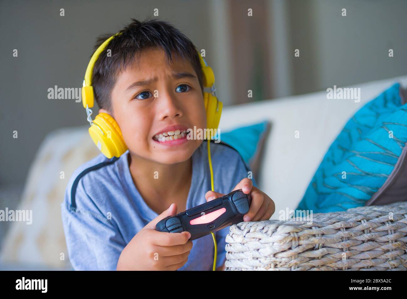 lifestyle portrait of Latin little kid excited and happy playing video ...