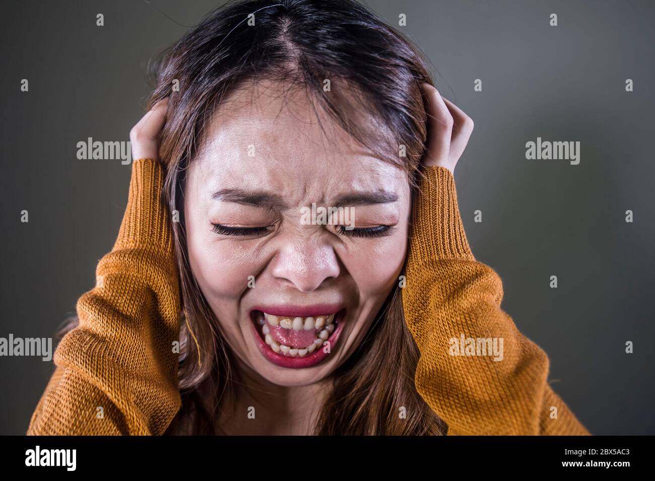 young crazy desperate and upset Asian Korean woman screaming scared and ...