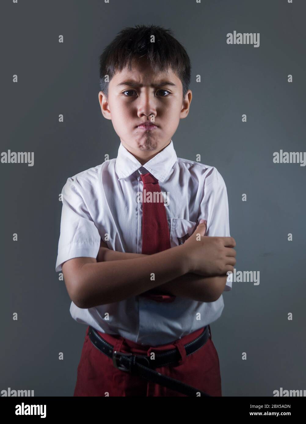 young boy 7 or 8 years old in school uniform feeling upset and angry ...