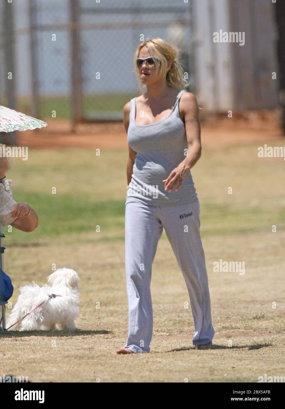 Pamela Anderson sitting on grass, eating burger in Malibu, CA May 2008 ...