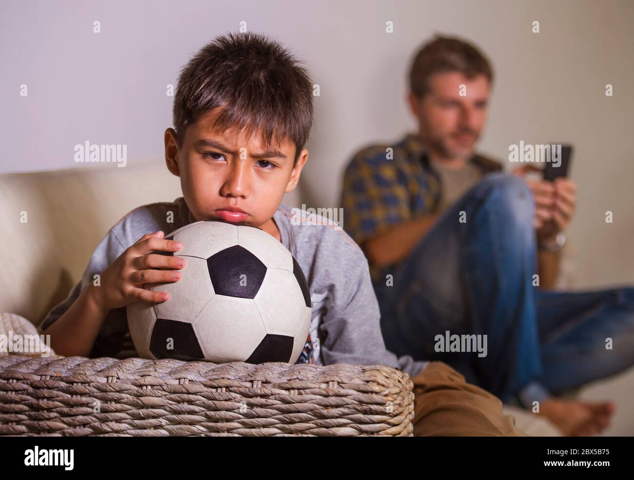 young sad and bored child at home couch feeling frustrated and ...