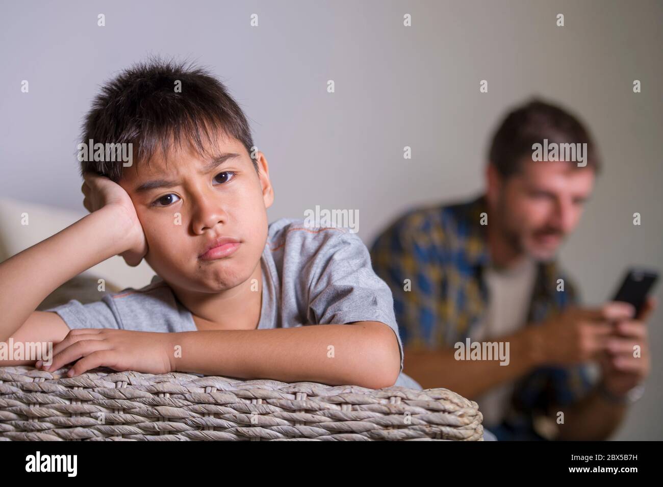 young sad and bored 7 or 8 years old child at home couch feeling ...