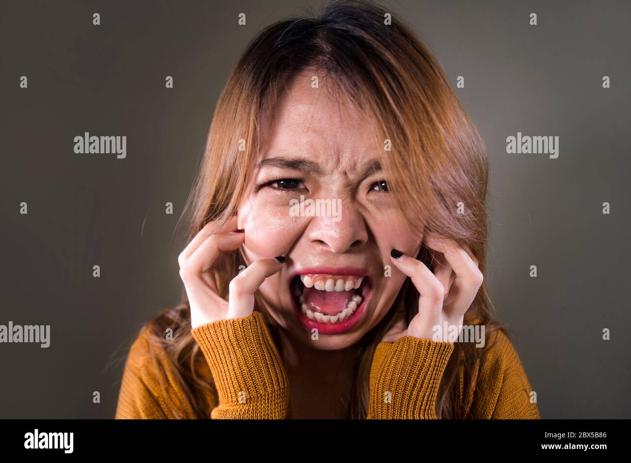 young crazy desperate and upset Asian Korean woman screaming scared and ...