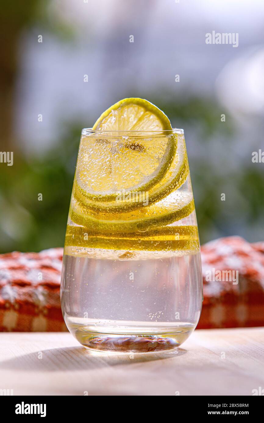 Lemonade with fresh lemon in glass on garden background Stock Photo - Alamy