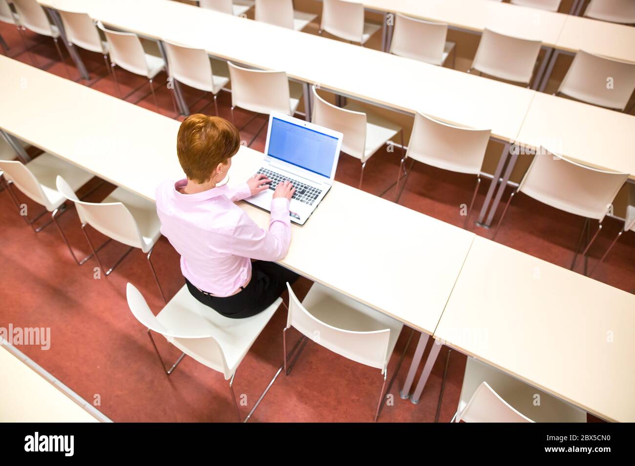 Pretty young college student with notebook, laptop studying in modern ...