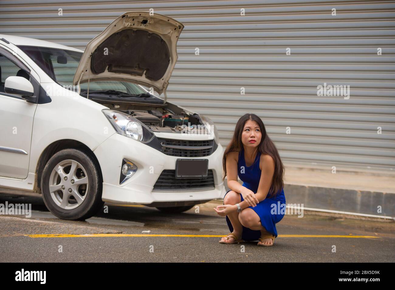 young desperate and worried Asian Chinese woman in stress stranded on ...