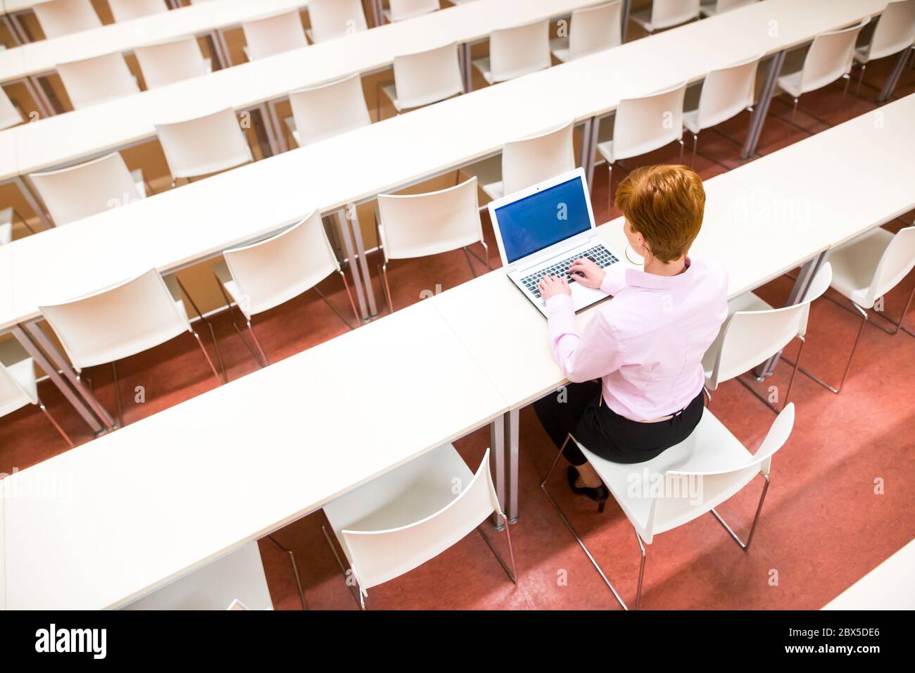 Pretty young college student with notebook, laptop studying in modern ...