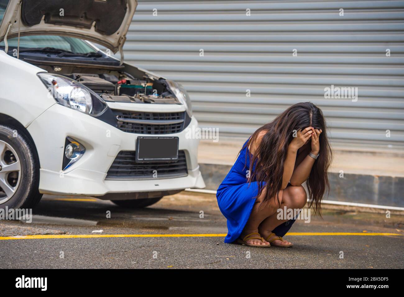 young desperate and worried woman in stress stranded on roadside with ...